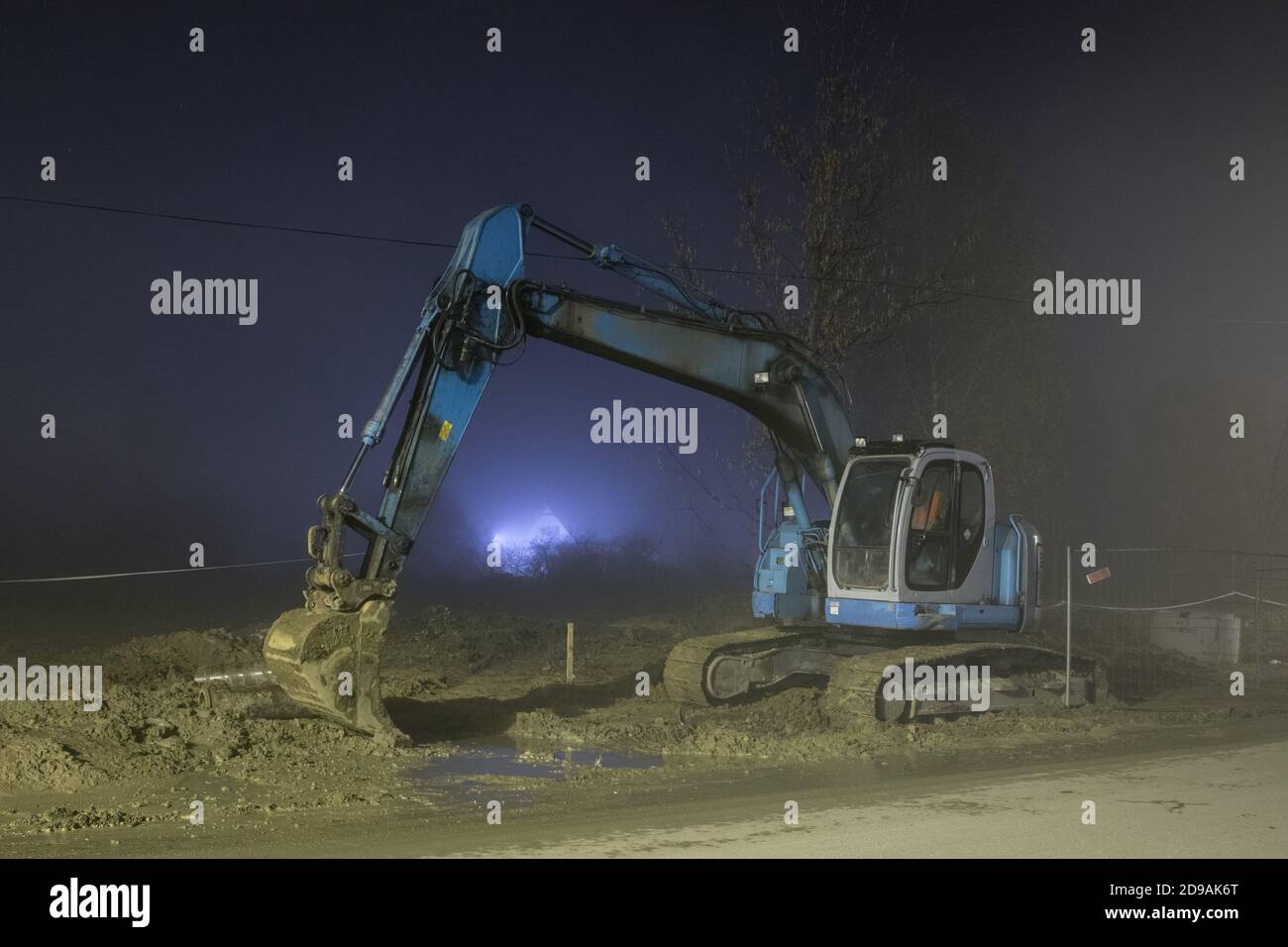 Blue excavator digger working at night on the street Stock Photo - Alamy