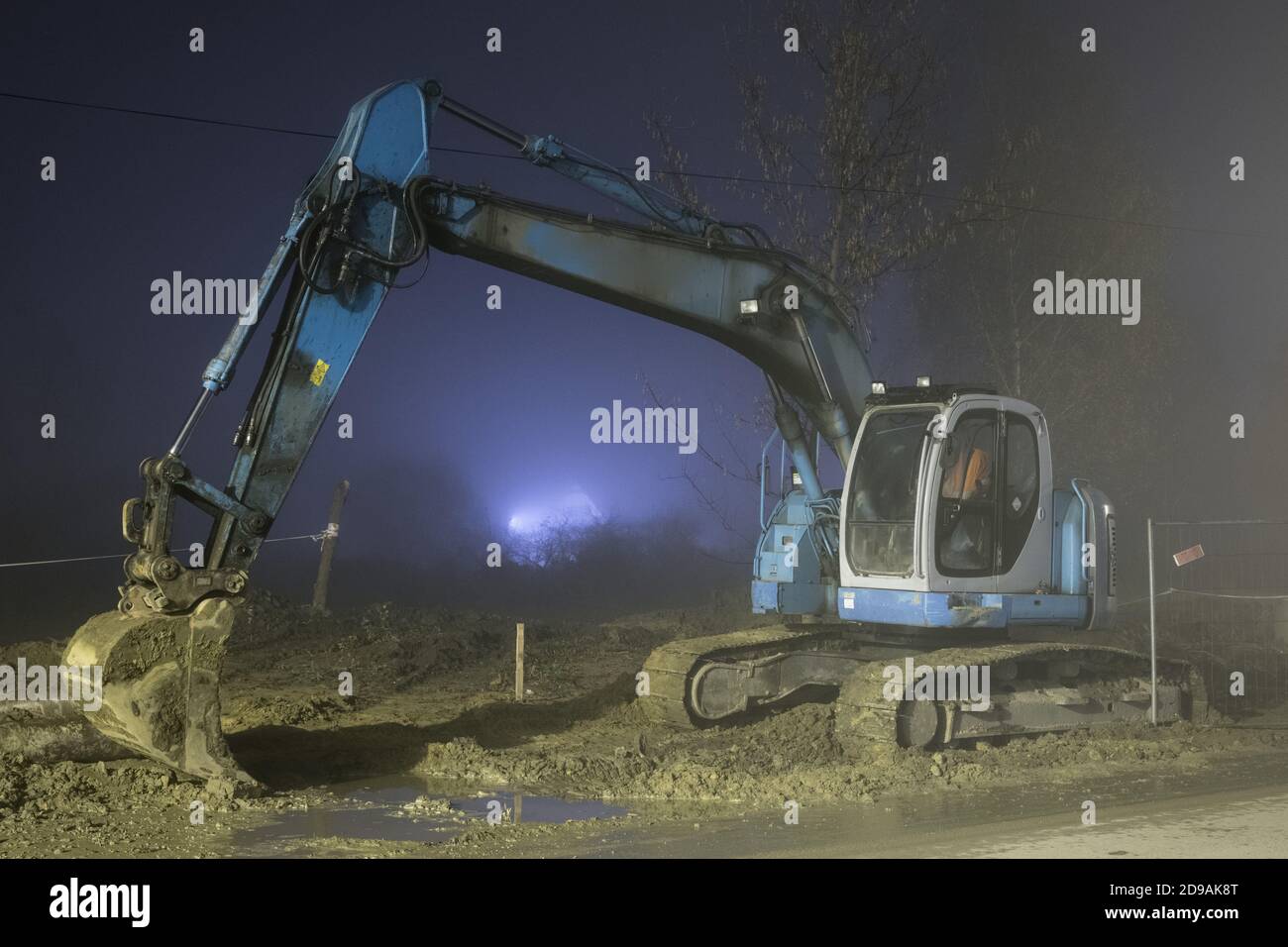 Blue excavator digger working at night on the street Stock Photo - Alamy