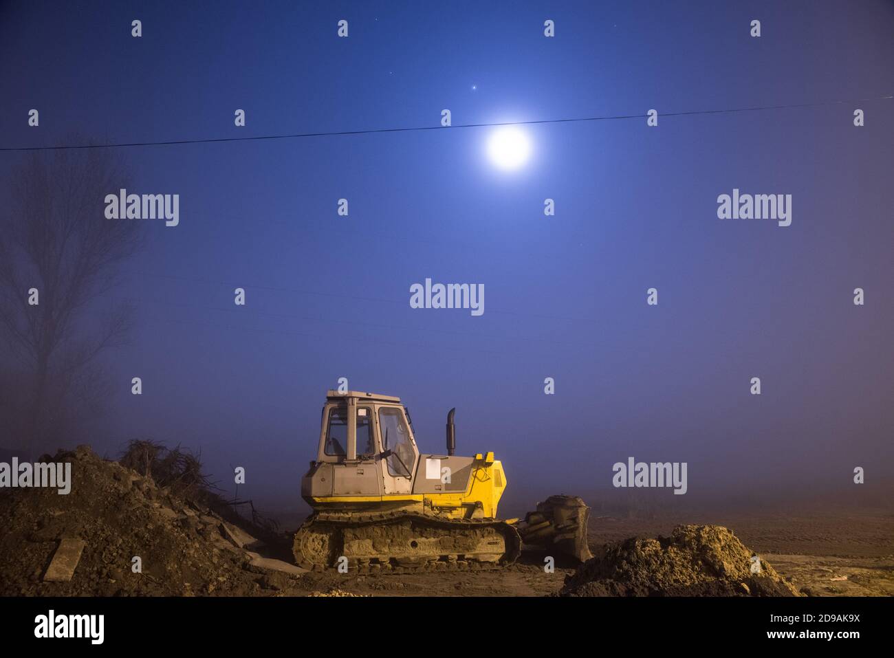 Blue excavator digger working at night on the street Stock Photo - Alamy