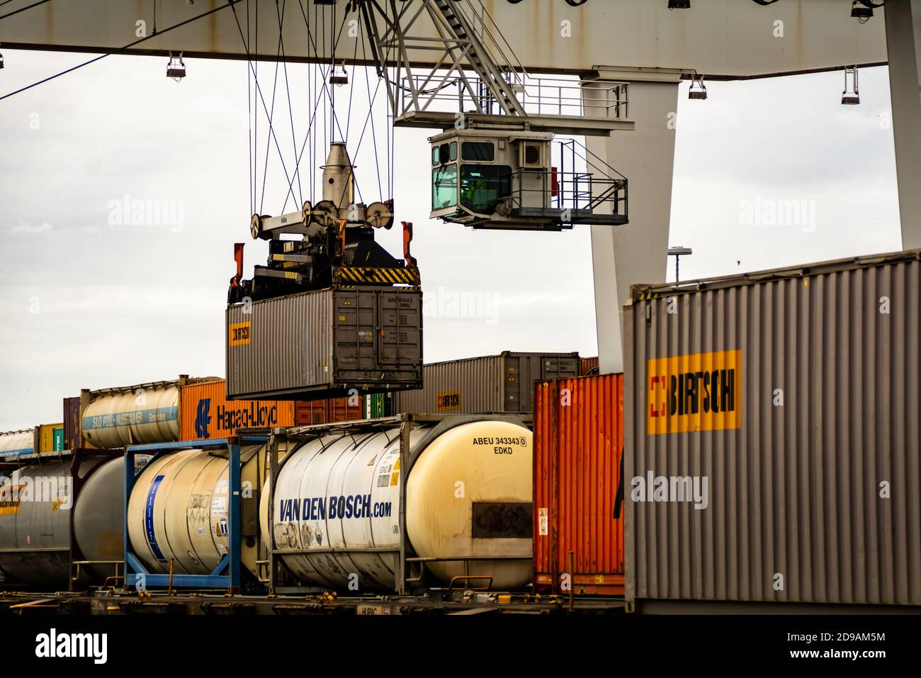 Crane loading and unloading shipping containers on a train in the ...