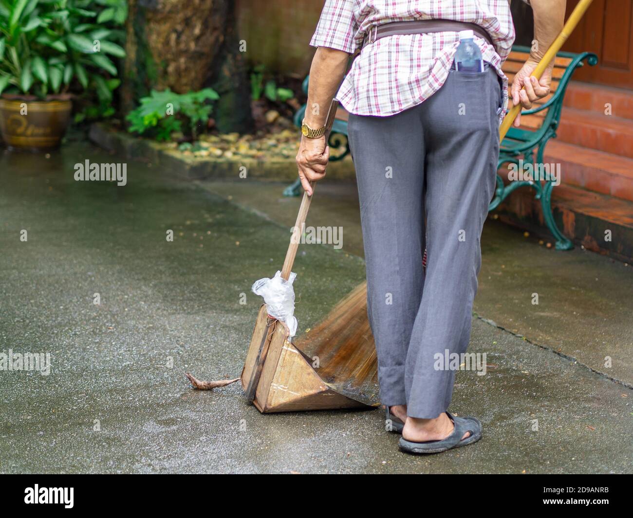 Back view of old man using broom sweep garbage at sidewalk Stock Photo ...