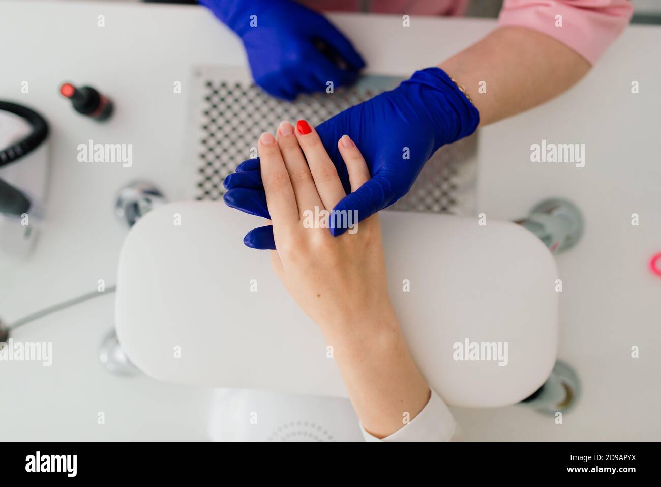 Female manicure master in beauty salon work with hands of the client ...