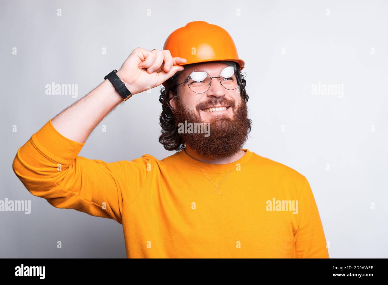 Portrait of cheerful young architect and wearing orange helmet Stock ...