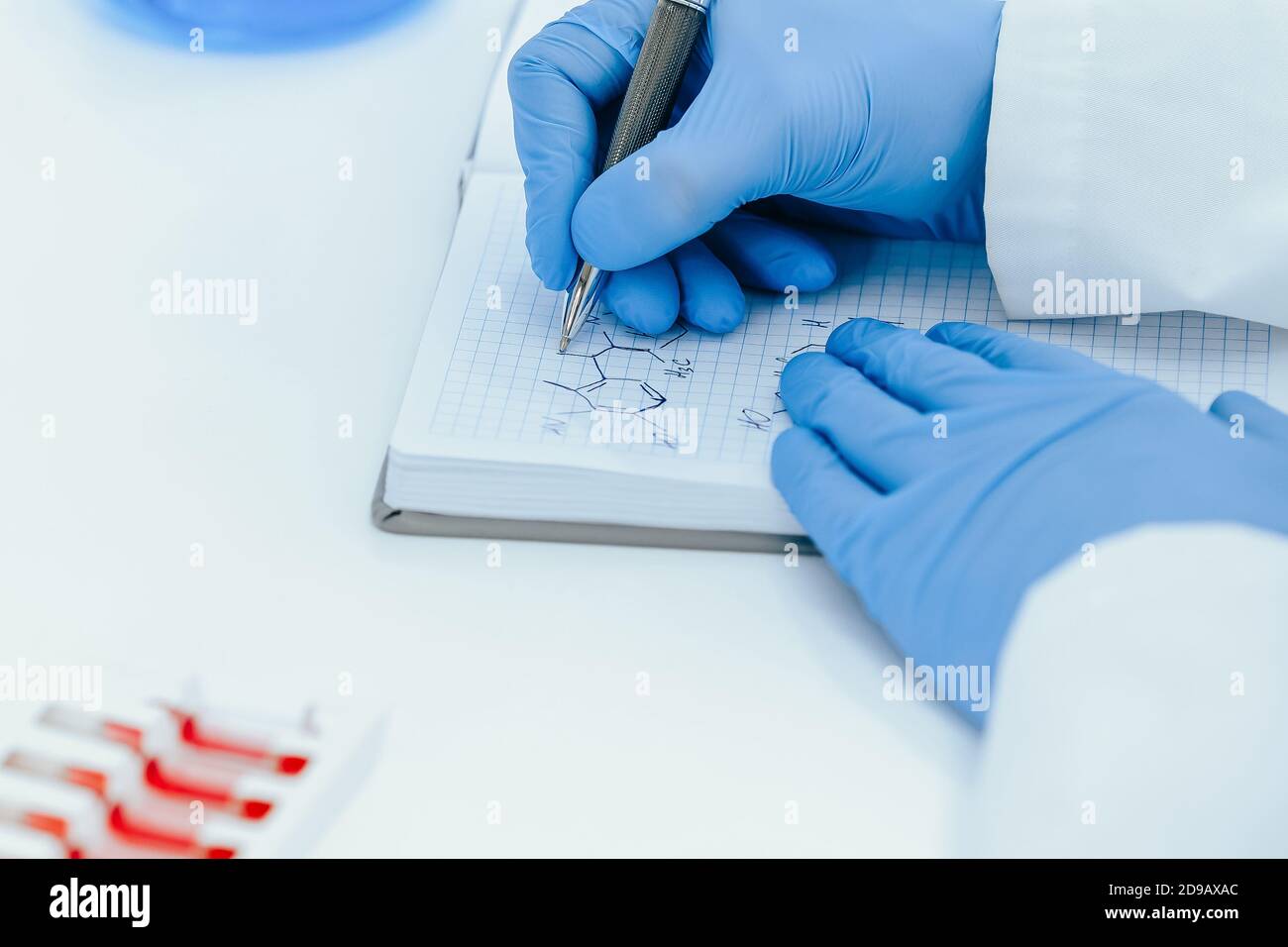 close up. scientist virologist recording test results in a journal ...