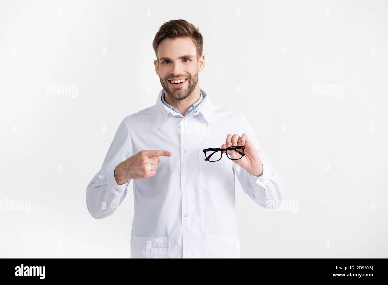 Front view of happy doctor pointing with finger at eyeglasses, while ...