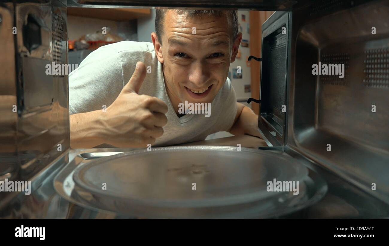 the man opens the microwave looks inside, and shows the class sign ...