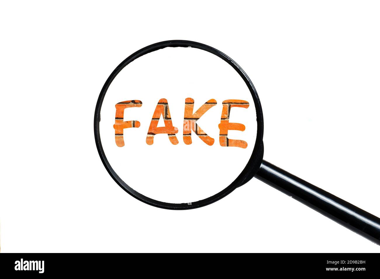 word fake and magnifying glass on white background. text on brick wall ...