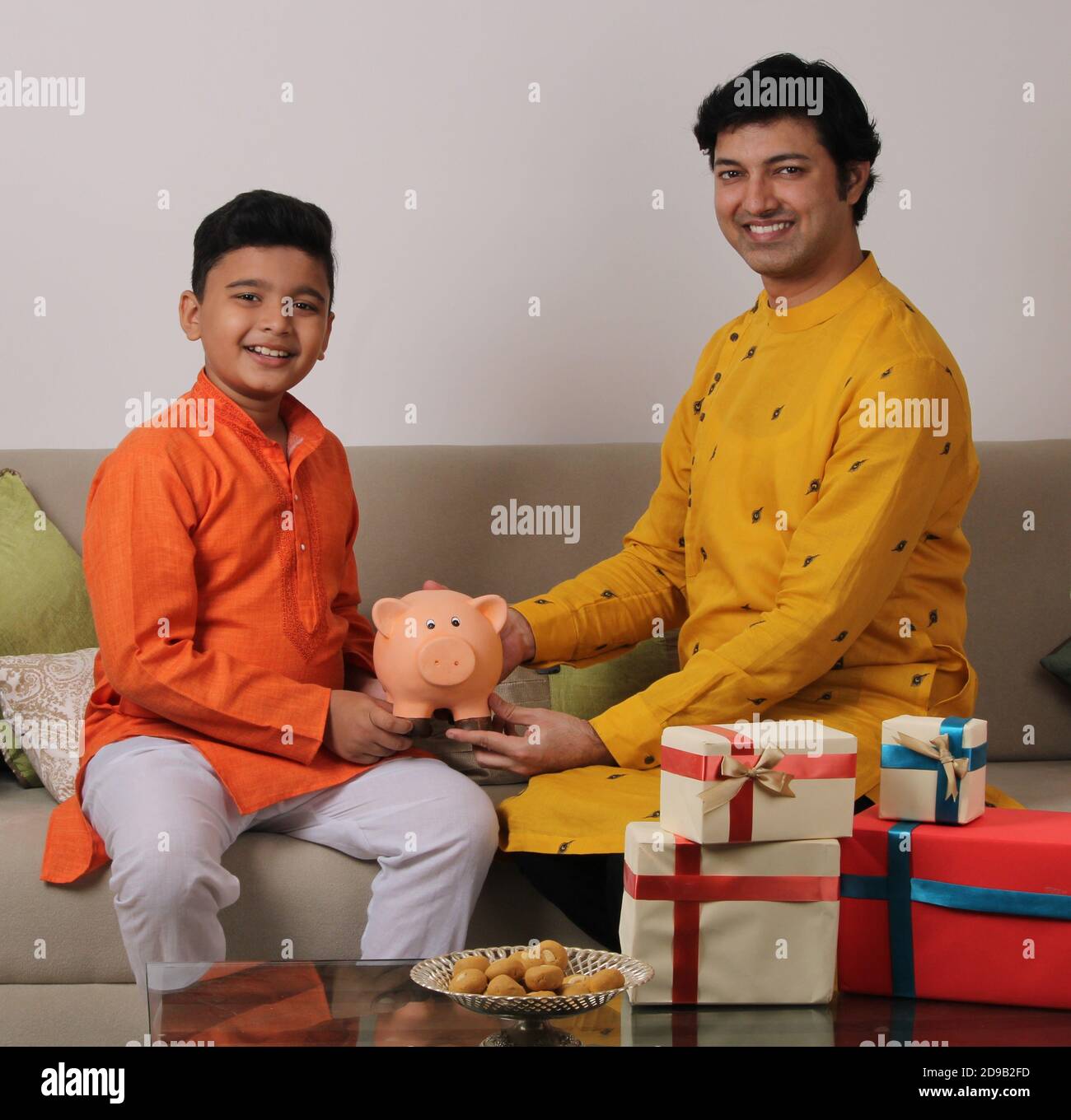 handsome Indian/asian father teaching importance of saving to his kid ...