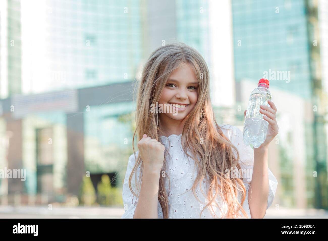 Water give me strength and power. Cute girl holding a bottle of water ...
