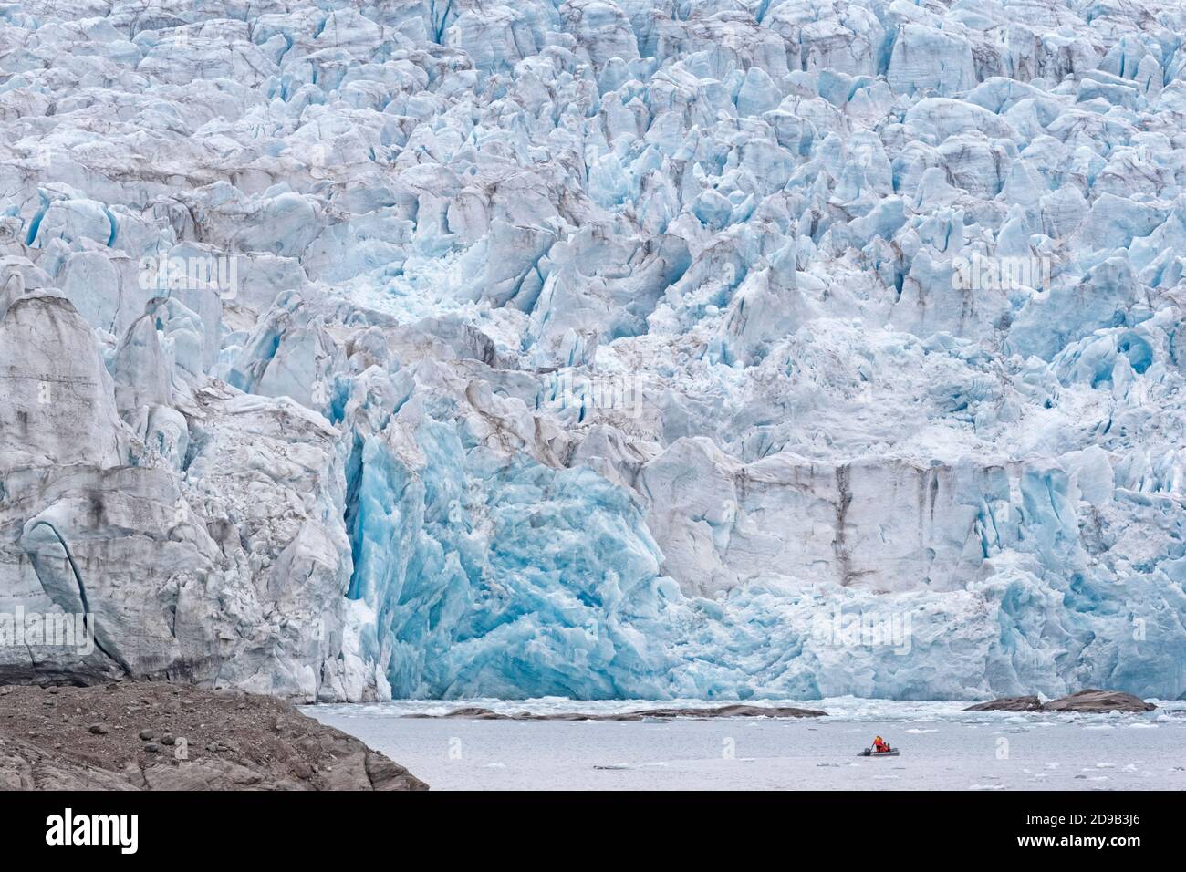 Scientists drive in an inflatable boat in front of Nordenskiold glacier ...