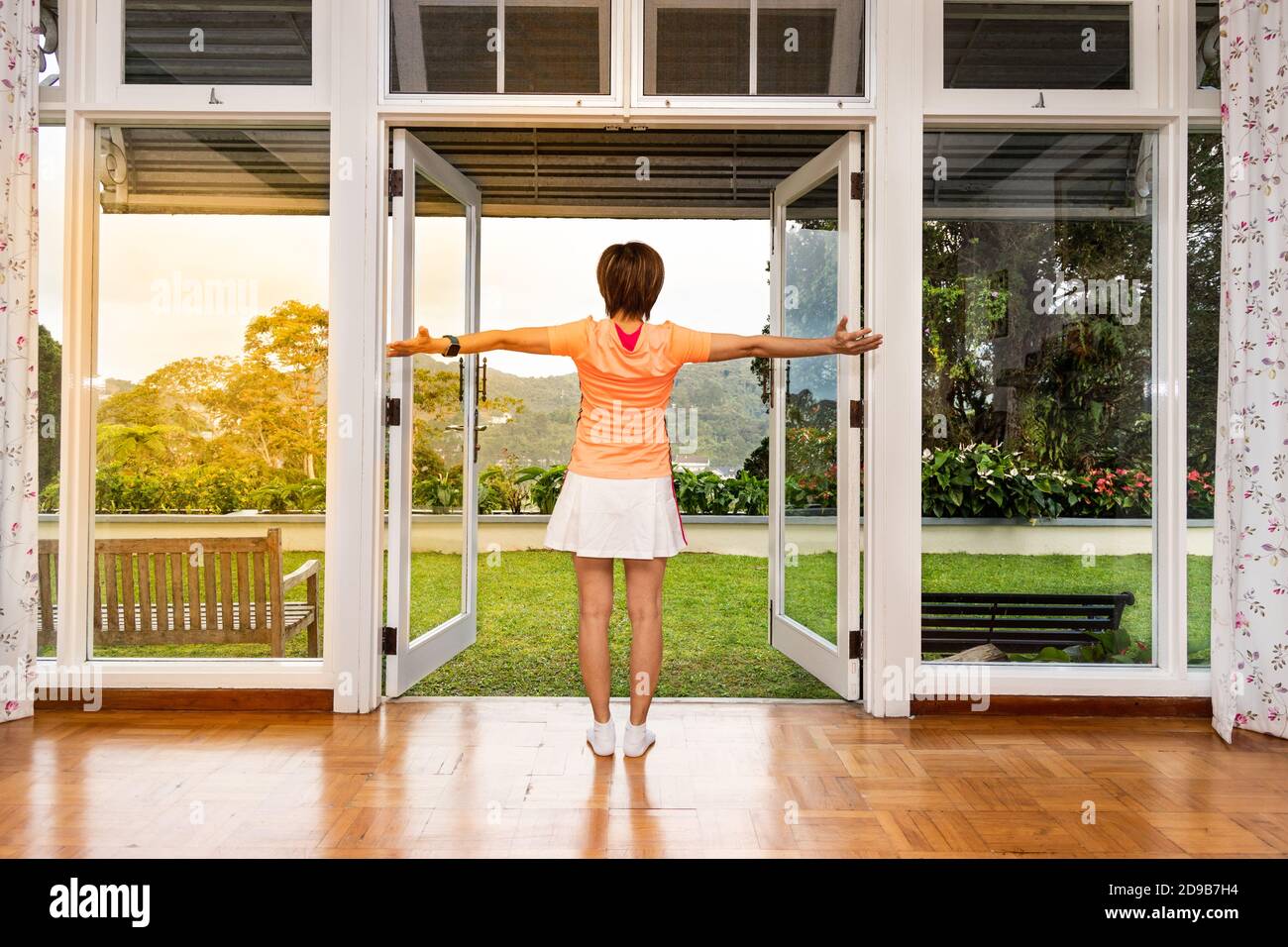 Women enjoy refreshing sunrise with greenaries scene from home interior ...
