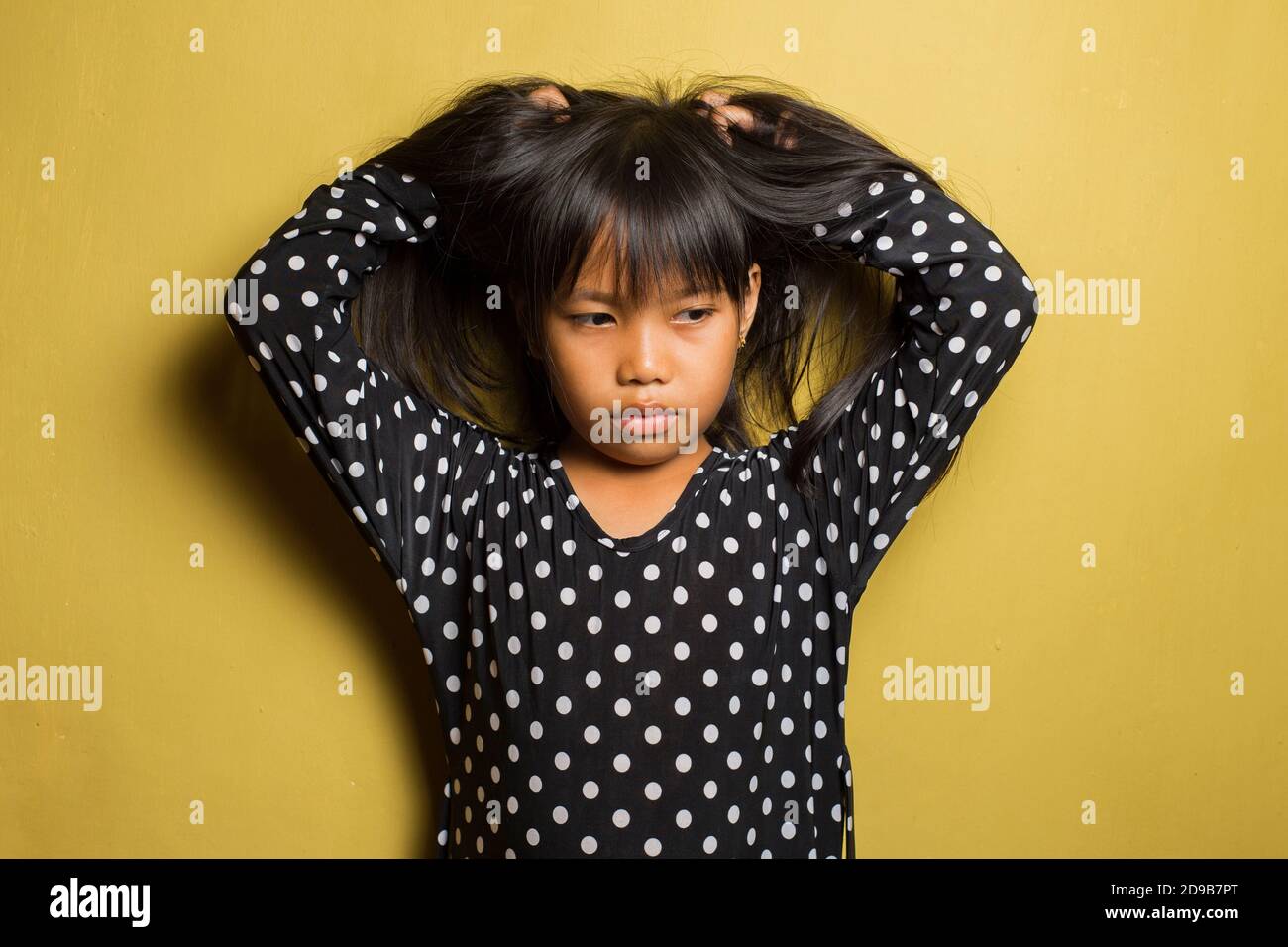 Asian little girl itching scratching her head Stock Photo - Alamy