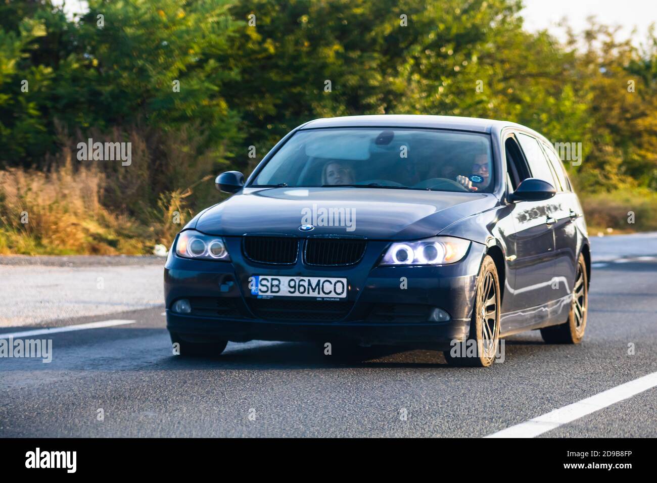 Traveling BMW car in motion on asphalt road, front view of car on ...