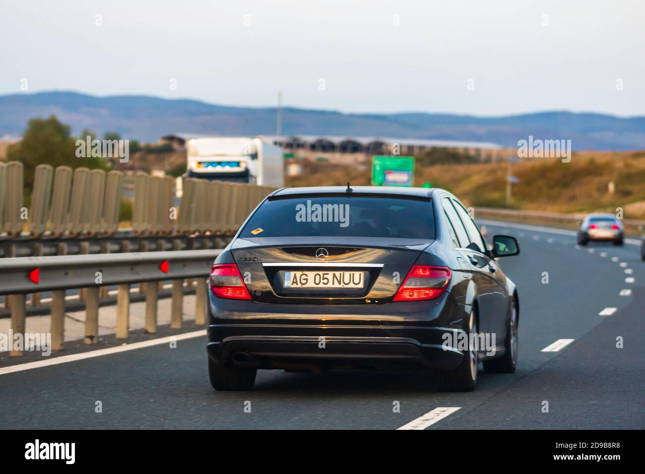 Traveling Mercedes car in motion on asphalt road, back view of car on ...