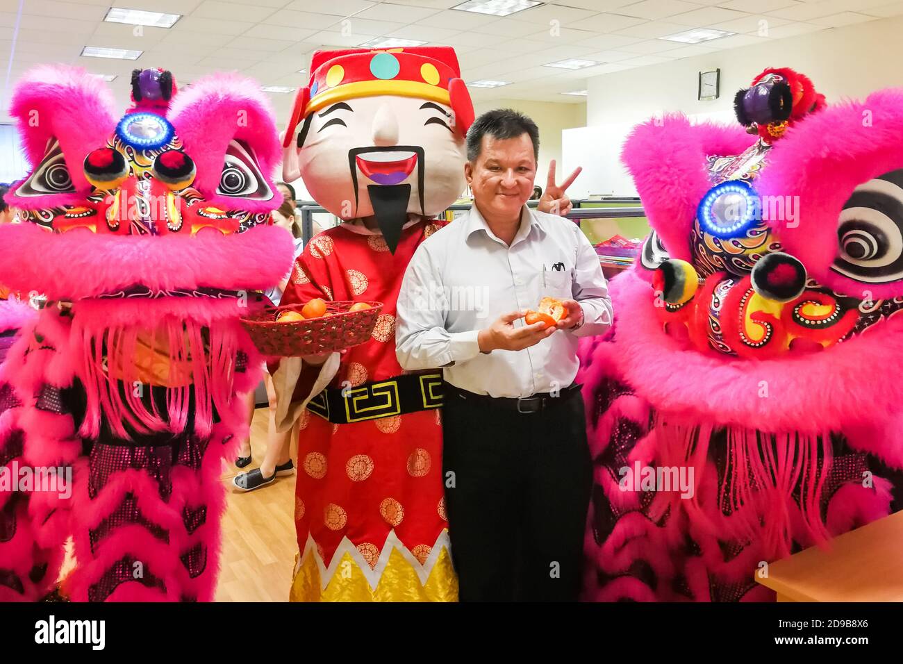Chinese business manager posing with two lions after dance performance ...