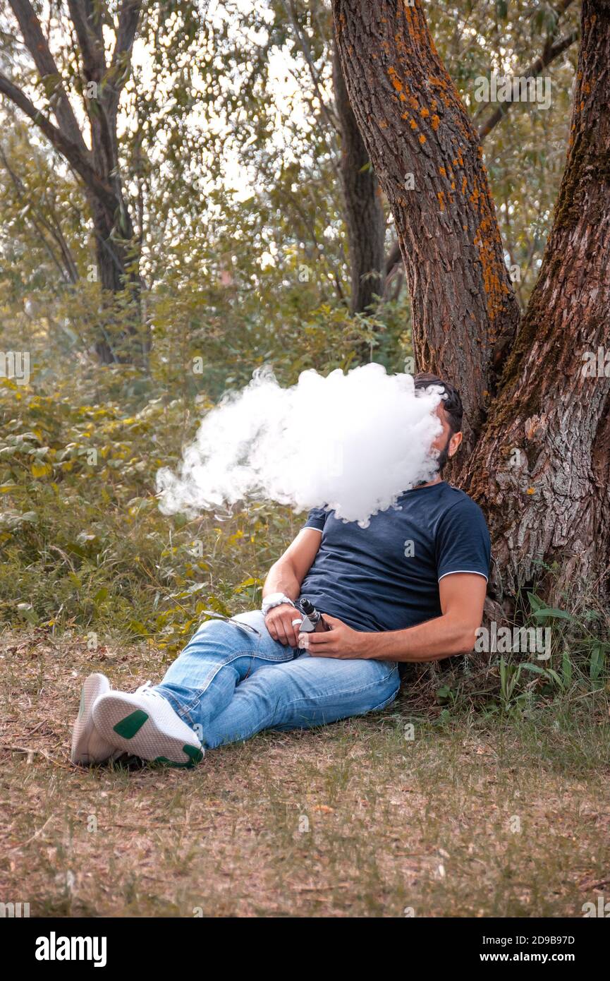 Brutal smoker smoke vape and exhals smoke cloud. The new technology ...