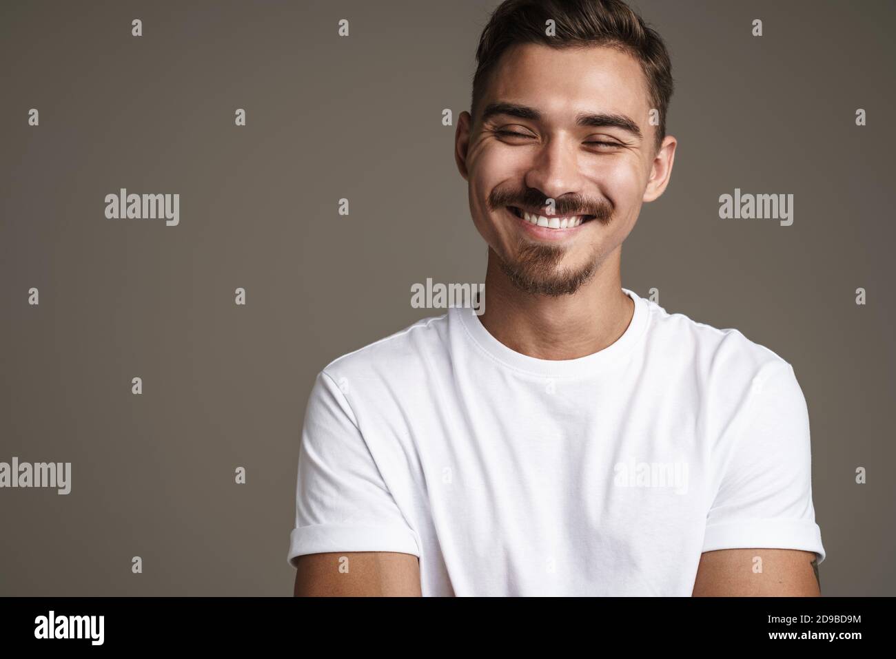 Image of joyful unshaven guy laughing while posing on camera isolated ...
