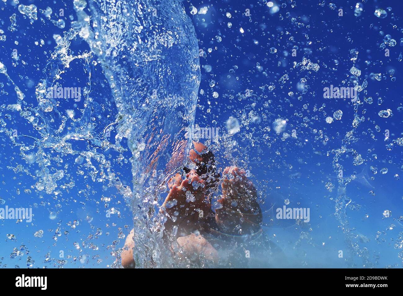 Man standing in sea splashing water, Italy Stock Photo - Alamy
