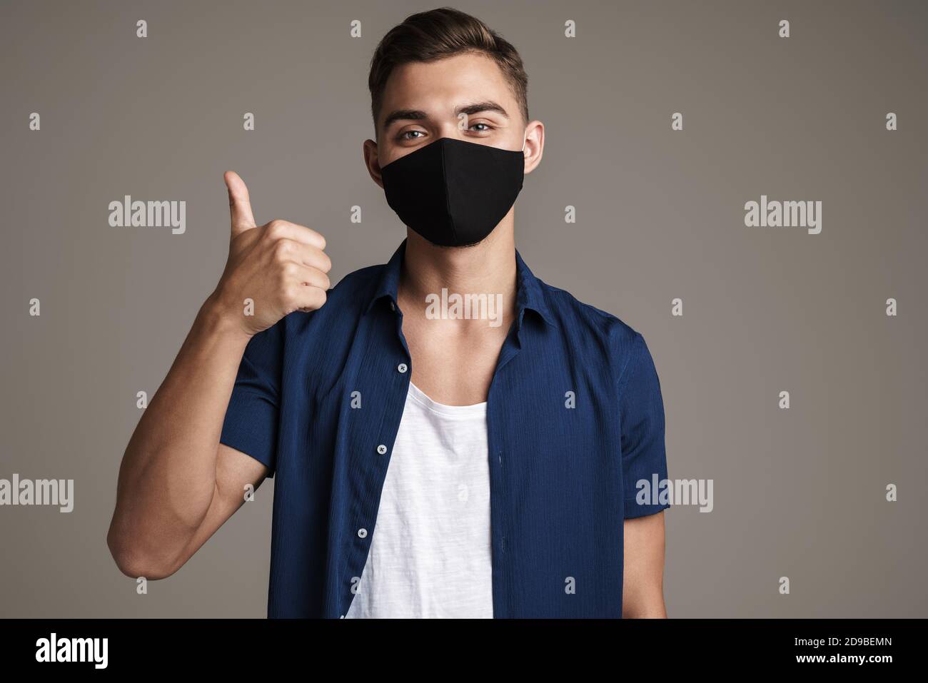Image of happy caucasian guy in face mask showing thumb up isolated ...