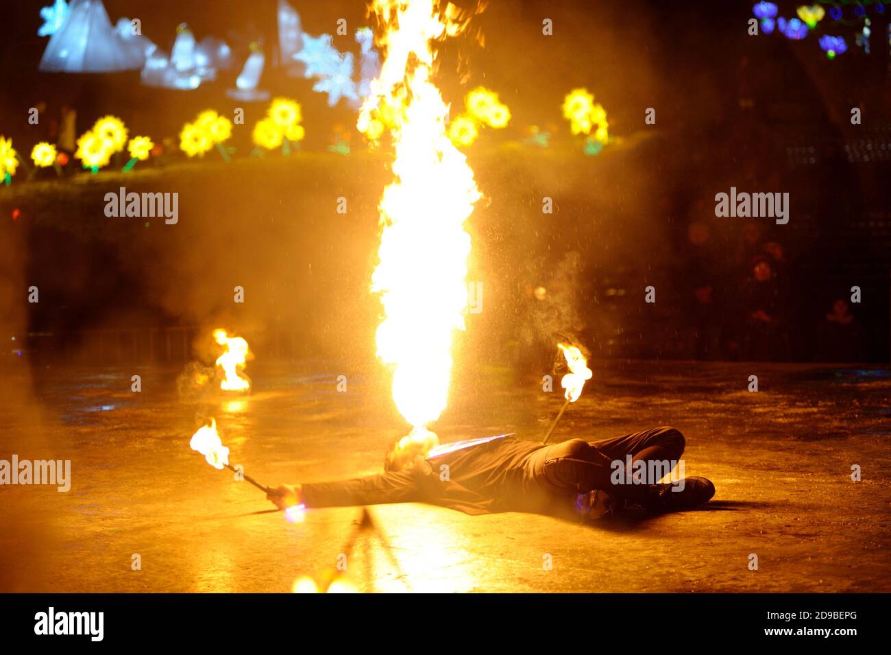 Fire juggler performing at night on stage, juggling with torches ...