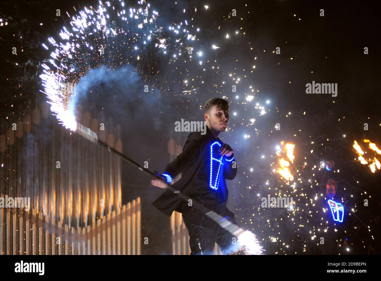 Fire juggler performing at night on stage, juggling with torches ...