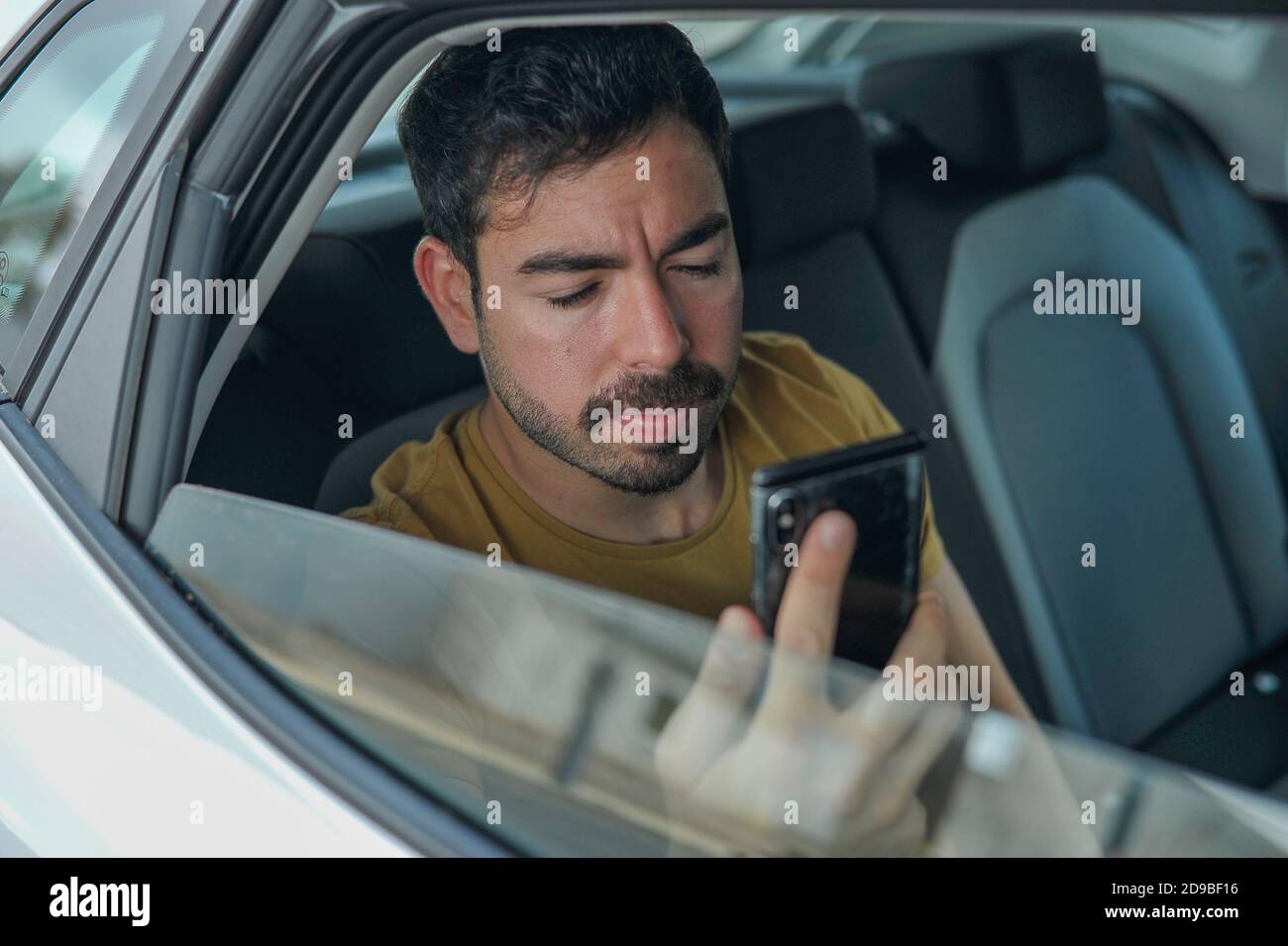 Young man chatting over phone in a car Stock Photo - Alamy