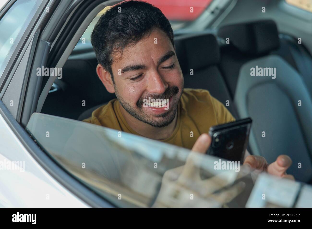 Young man chatting over phone in a car Stock Photo - Alamy