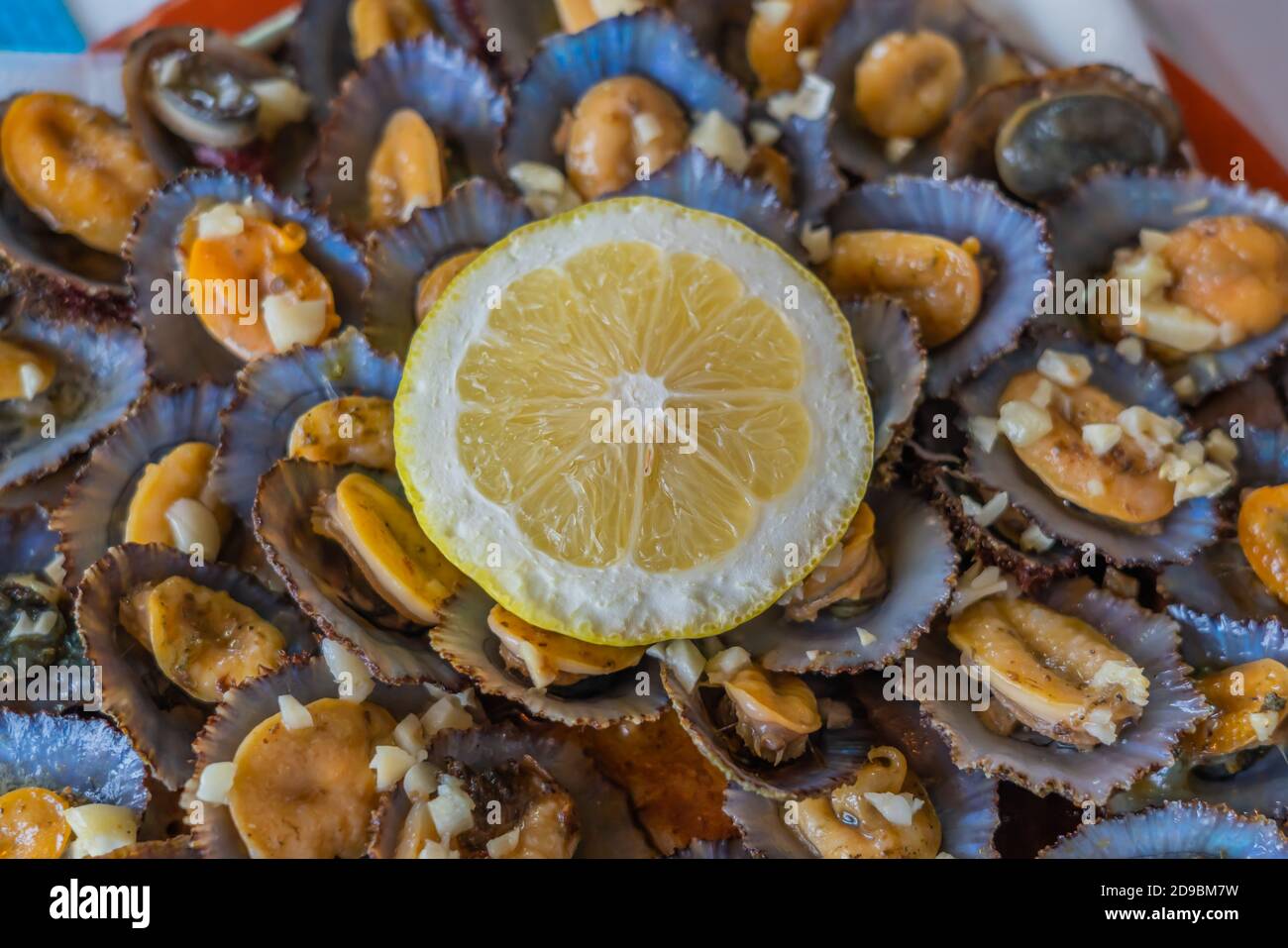 tasty seafood - grilled limpets served with lemon. Lapas grelhadas ...