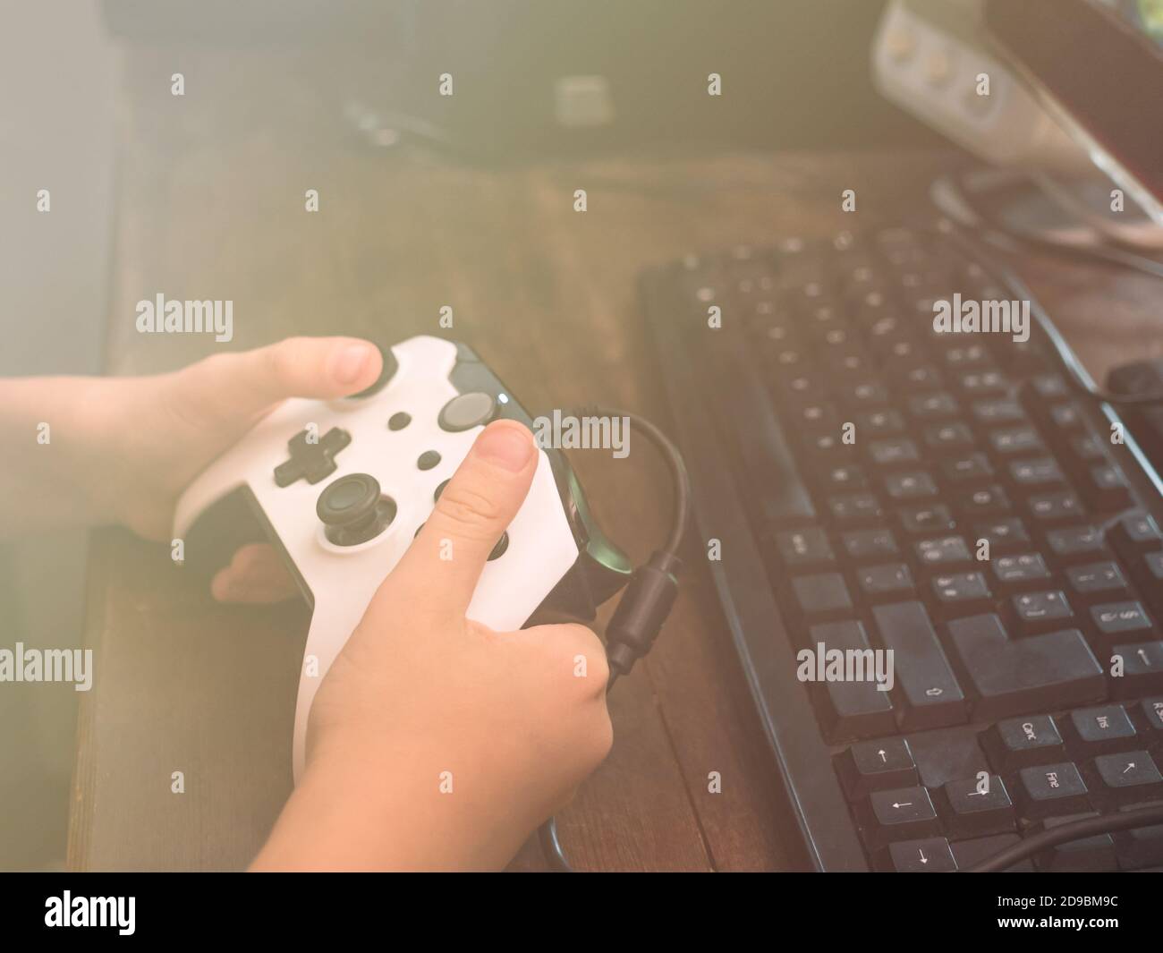 Little kid playing with joystick in front of PC Stock Photo - Alamy