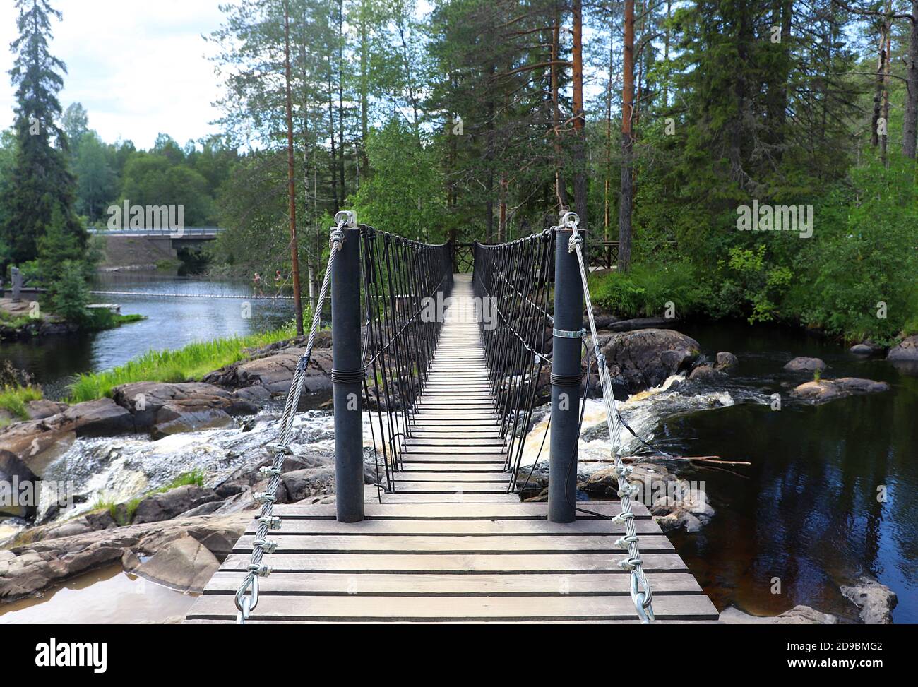 Hanging or rope bridge above a waterfall. Perspective view, green trees ...
