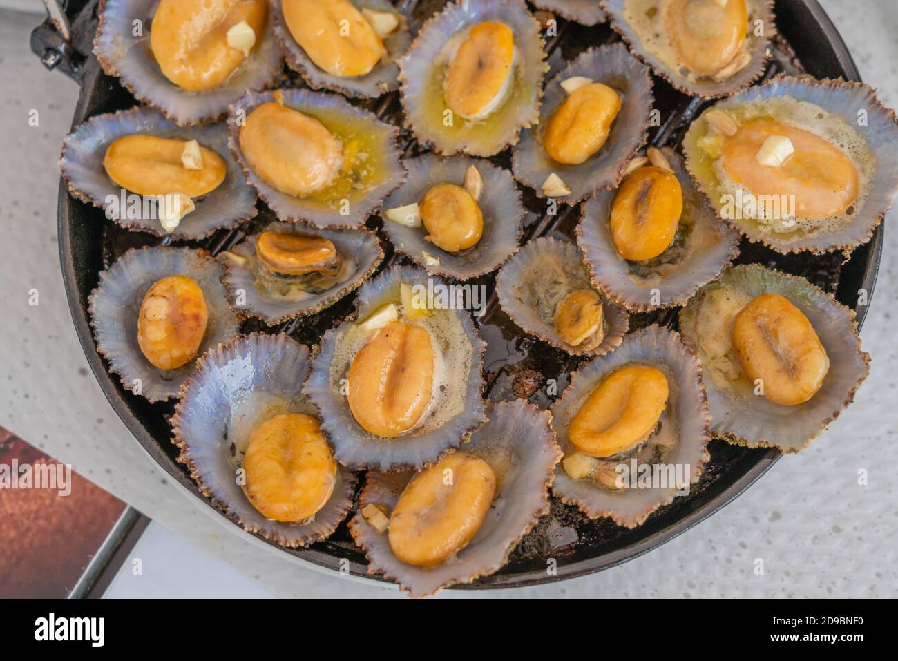 tasty seafood - grilled limpets served on black plate. Lapas grelhadas ...
