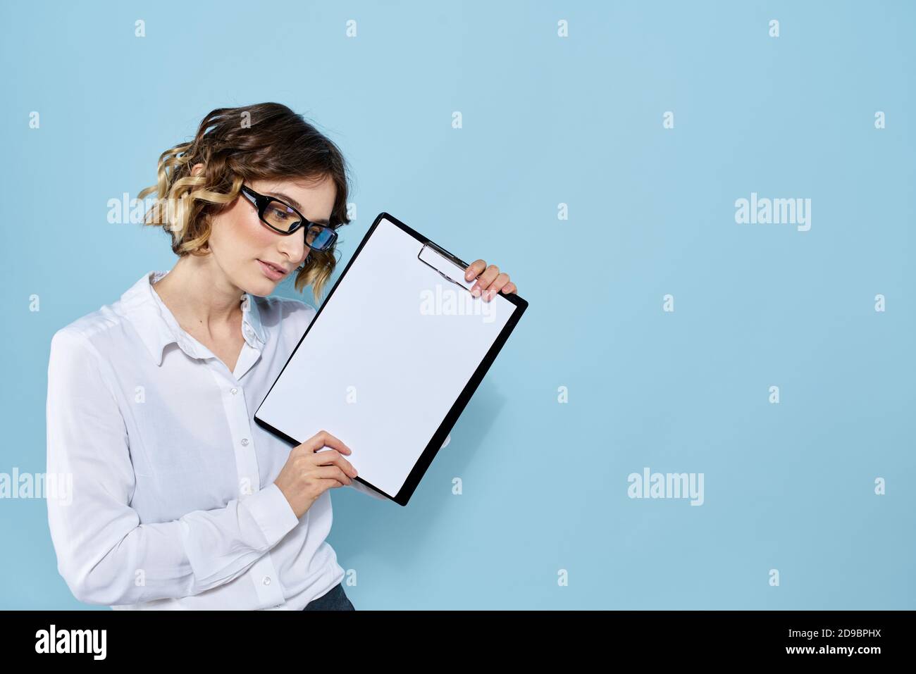 Business woman with documents in a folder on a blue background and in a ...