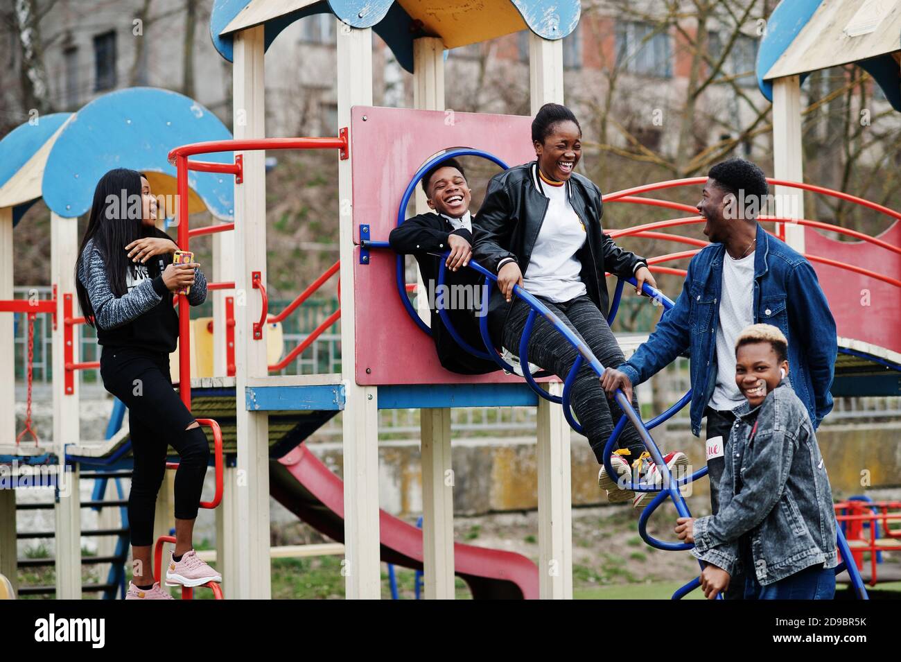 Young millennials african friends on playground, slide and swing. Happy ...