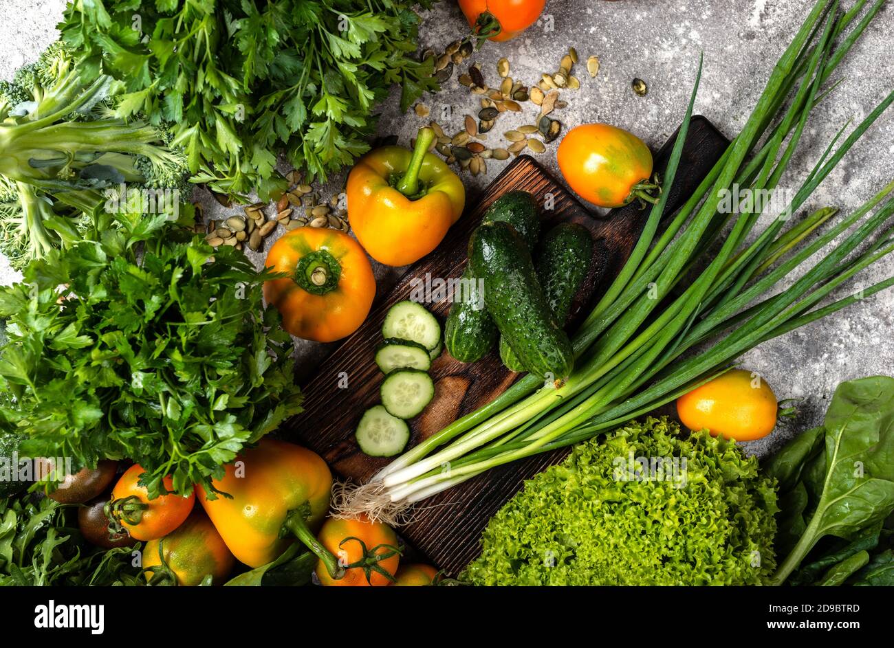 Vegetables and greens with chopping board on the table. Top view Stock ...