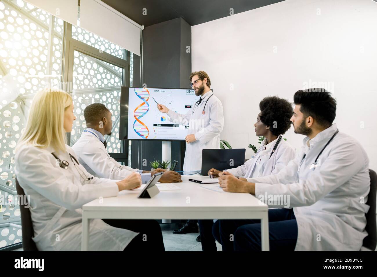 Team of multiethnic doctors in conference room, looking at their ...