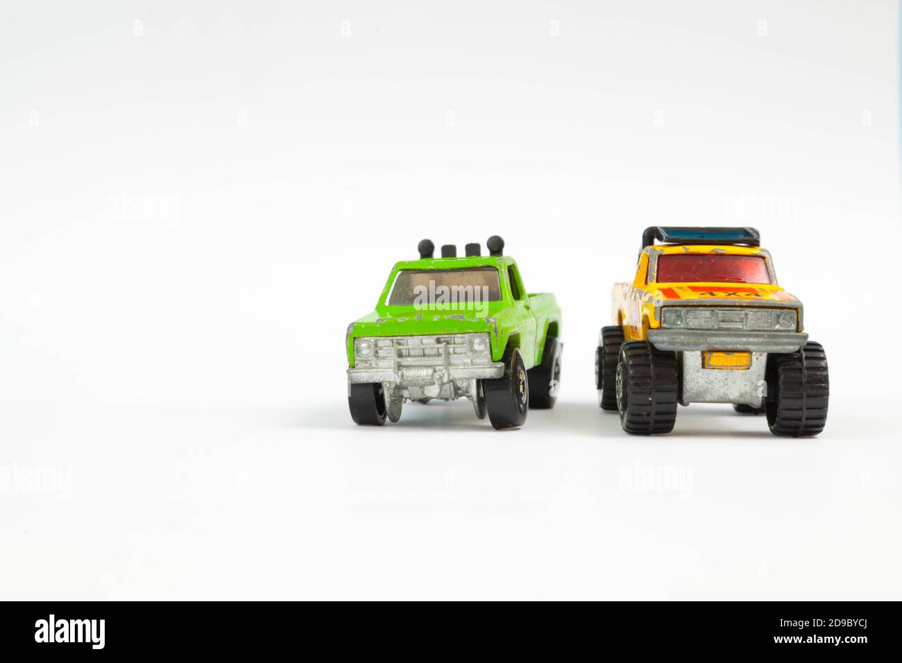 Green and Yellow toy 4 wheel drive pickup trucks on a white background ...