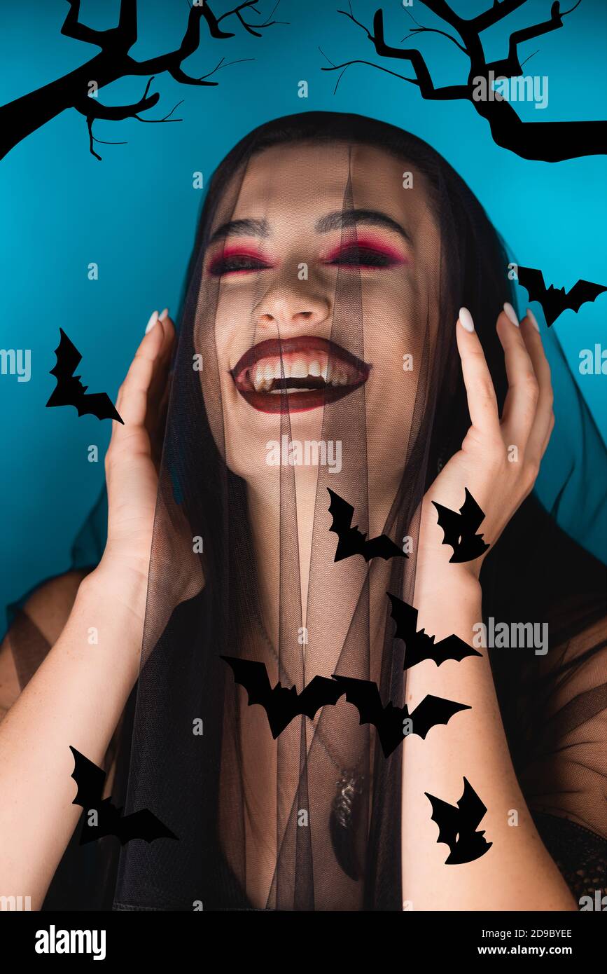 evil woman with black makeup, closed eyes and veil laughing near ...