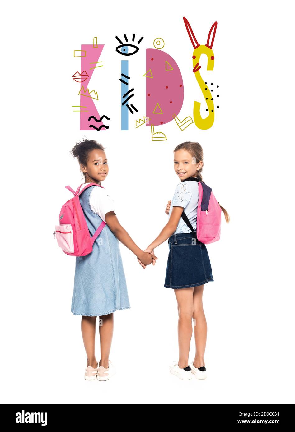 multicultural schoolgirls with backpacks holding hands and looking at ...