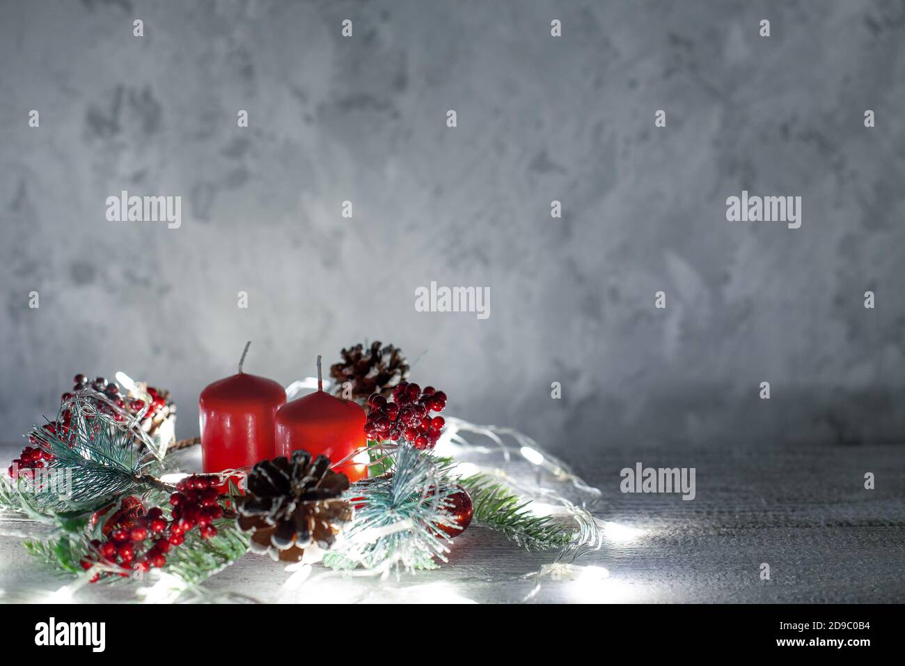mock up of a red candle, Christmas tree branches, cones, lights ...