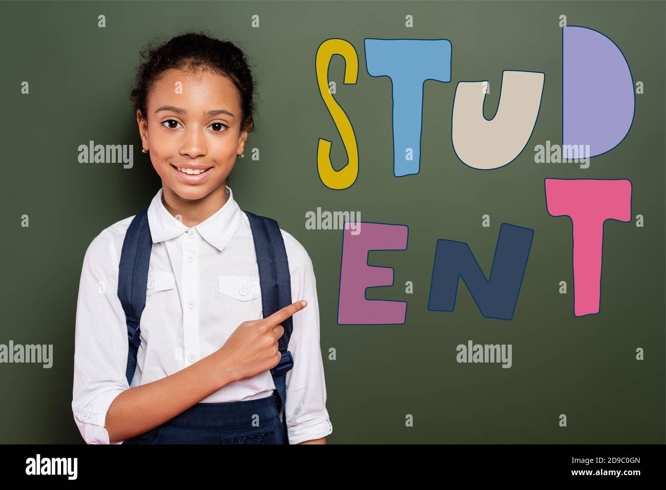 african american schoolgirl pointing with finger at green chalkboard ...