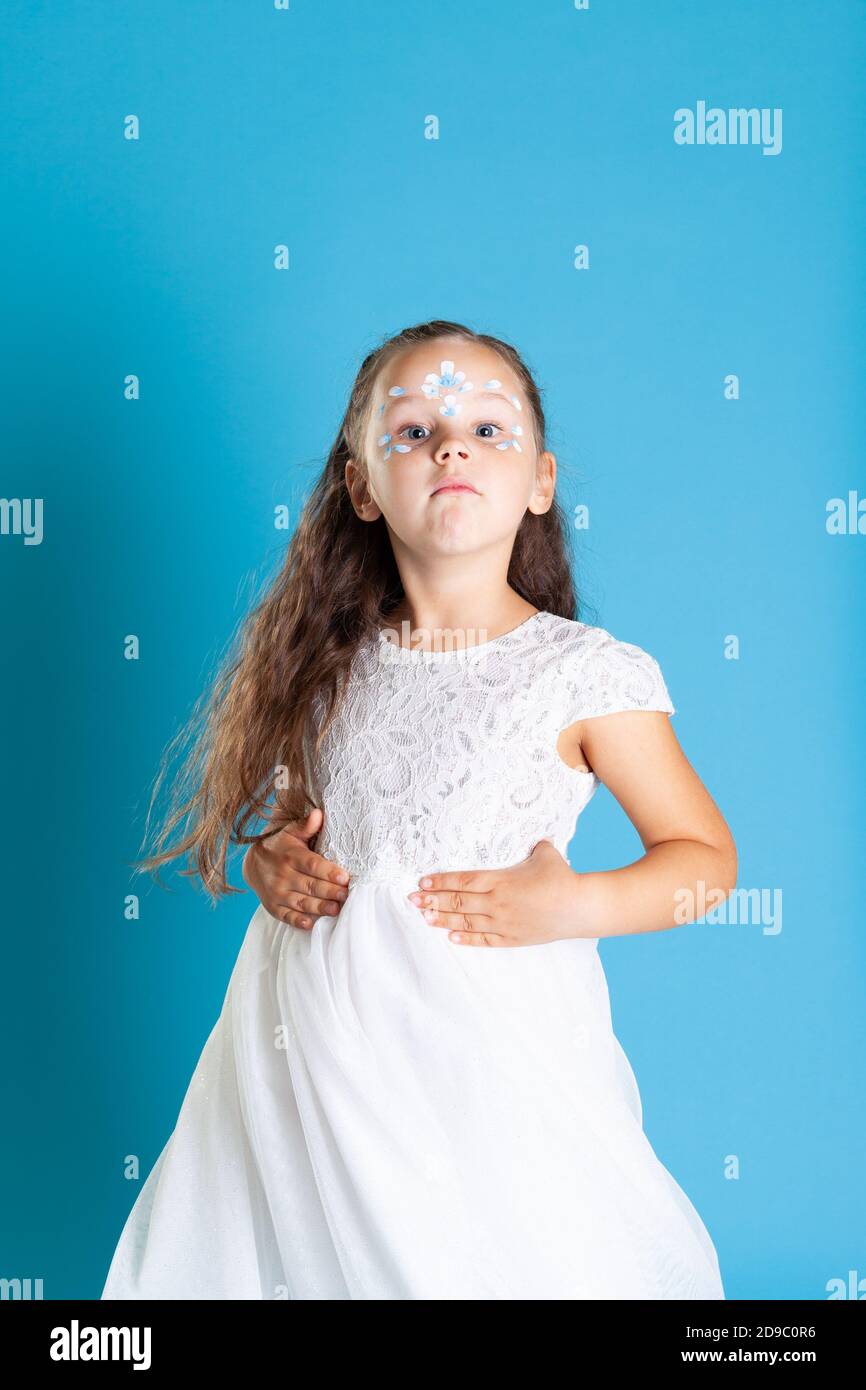 portrait of a surprised girl in a white Princess dress and snow Queen ...
