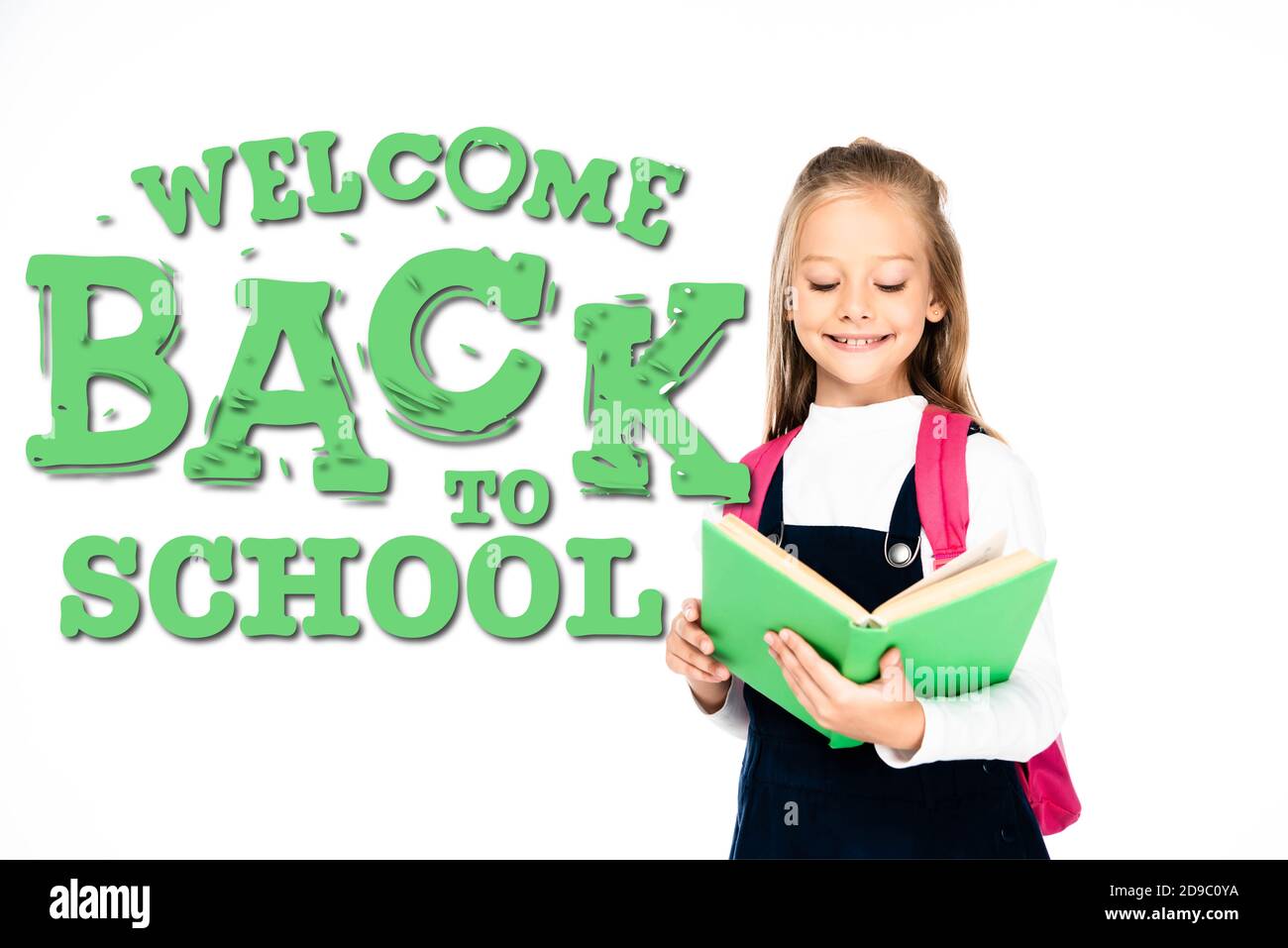 schoolgirl smiling while reading book isolated on white, welcome back ...