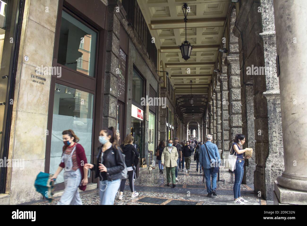 Bologna: people with surgical masks walk under the Bolognese arcades ...