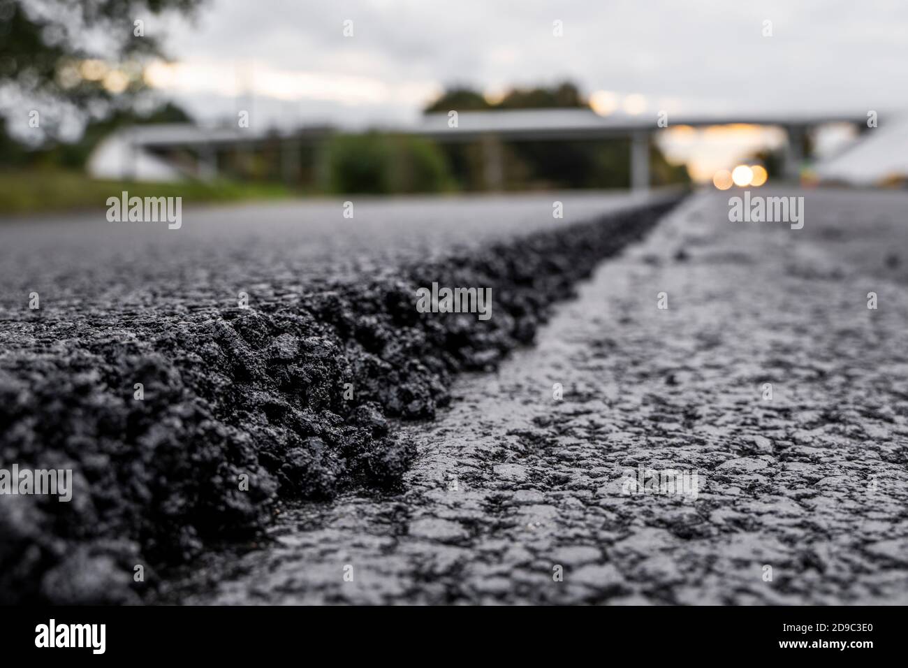 A large layer of fresh hot asphalt. Layer of asphalt raw material in a ...