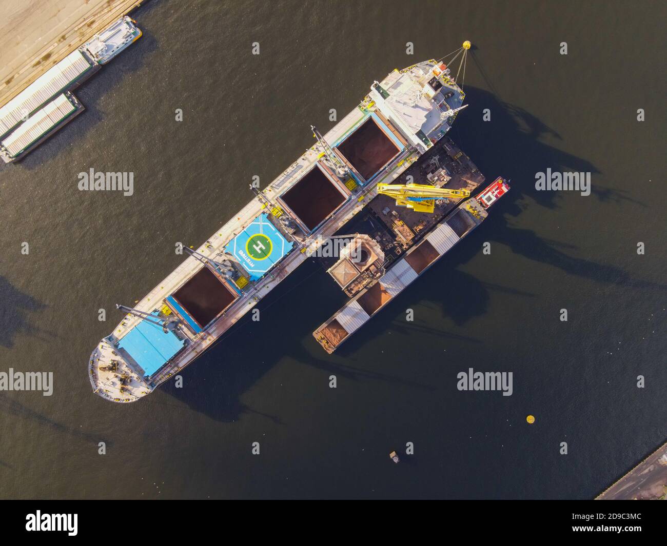 Loading of a docked ship in a industrial harbour Stock Photo - Alamy
