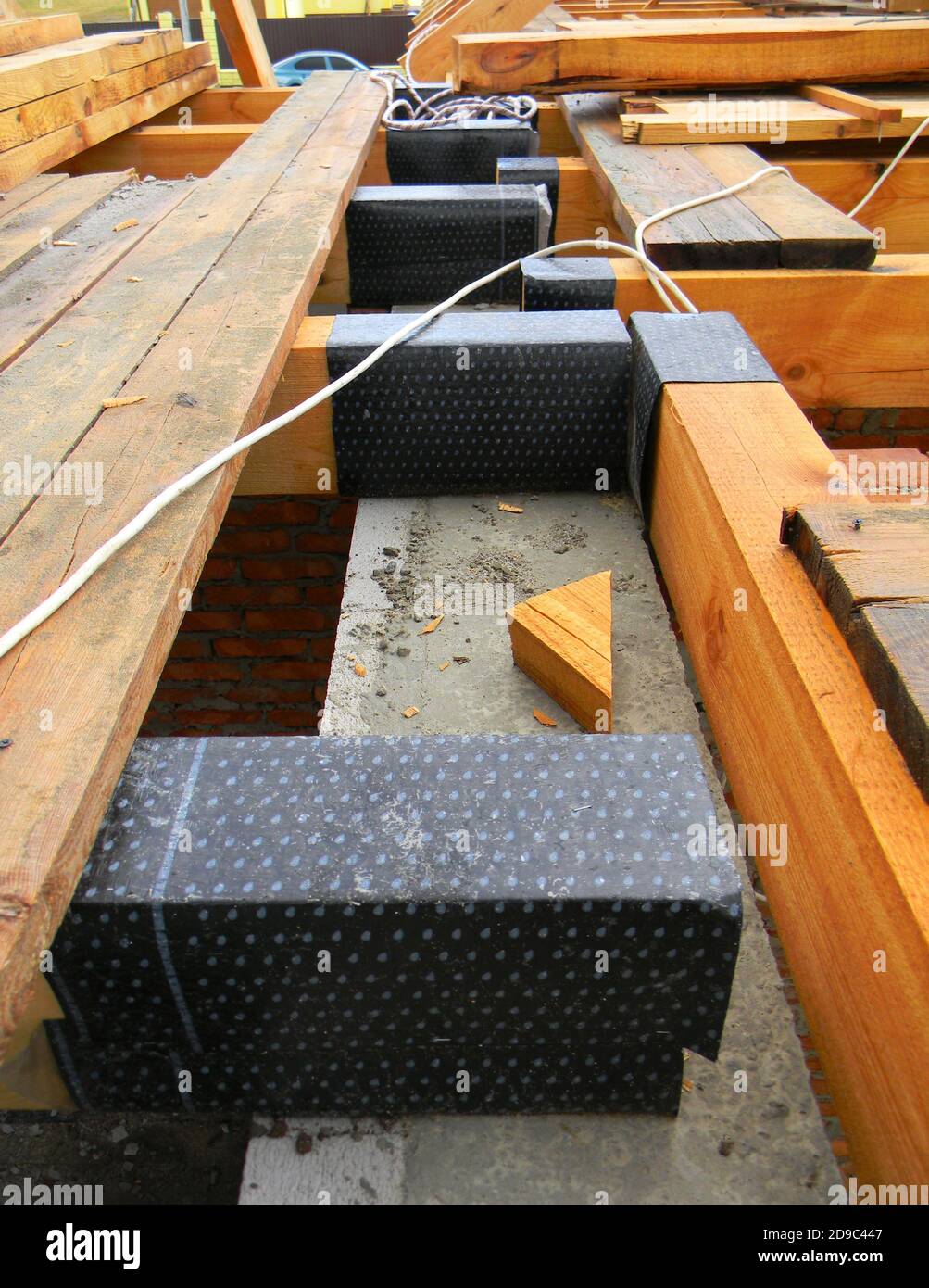 Wooden roof beams installation isolated with bitumen waterproofing ...