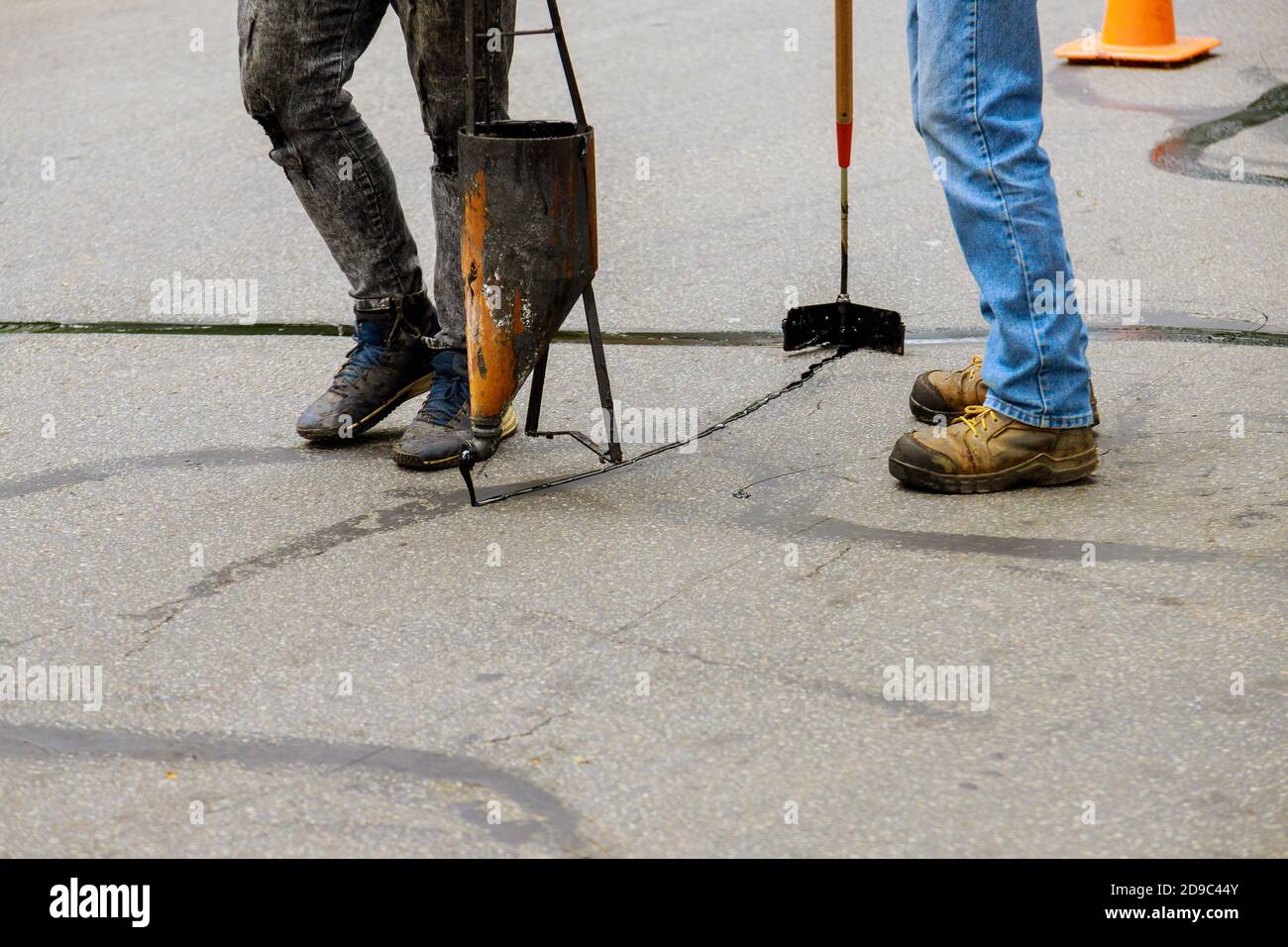 Restoration work applying liquid sealer to asphalt a road protective ...