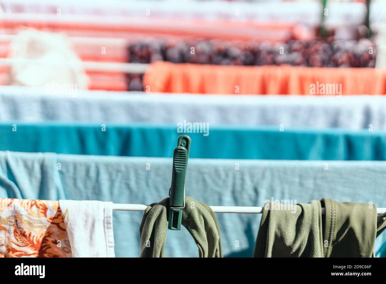 Color clothes hung out to dry in the bright warm sun outdoors at city ...