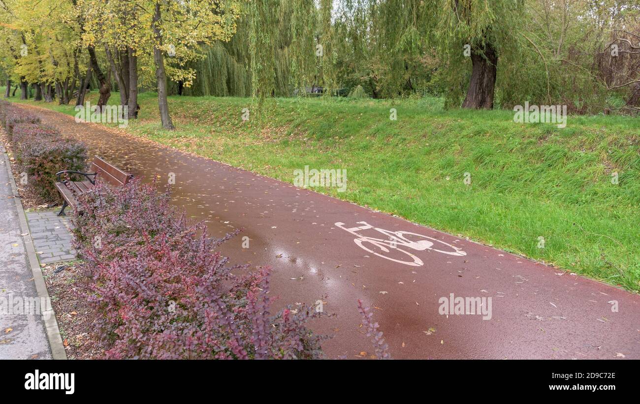 Bike lane sighn on a red bicycle path in a park after rain Stock Photo ...