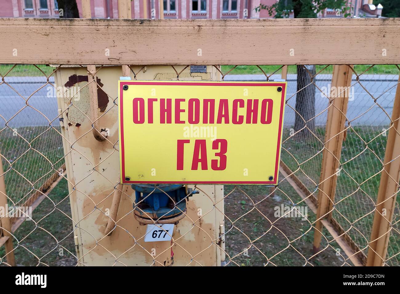A yellow plaque that reads 'Fire Gas' on a fence made of metal mesh ...